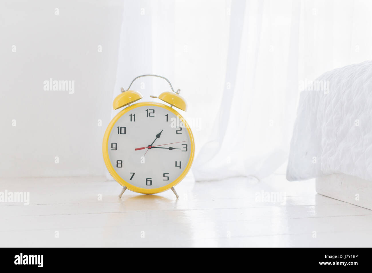 Huge alarm clock in white room interior Stock Photo - Alamy