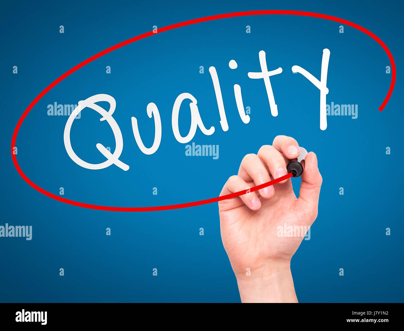 Man Hand writing Quality with marker on transparent wipe board ...