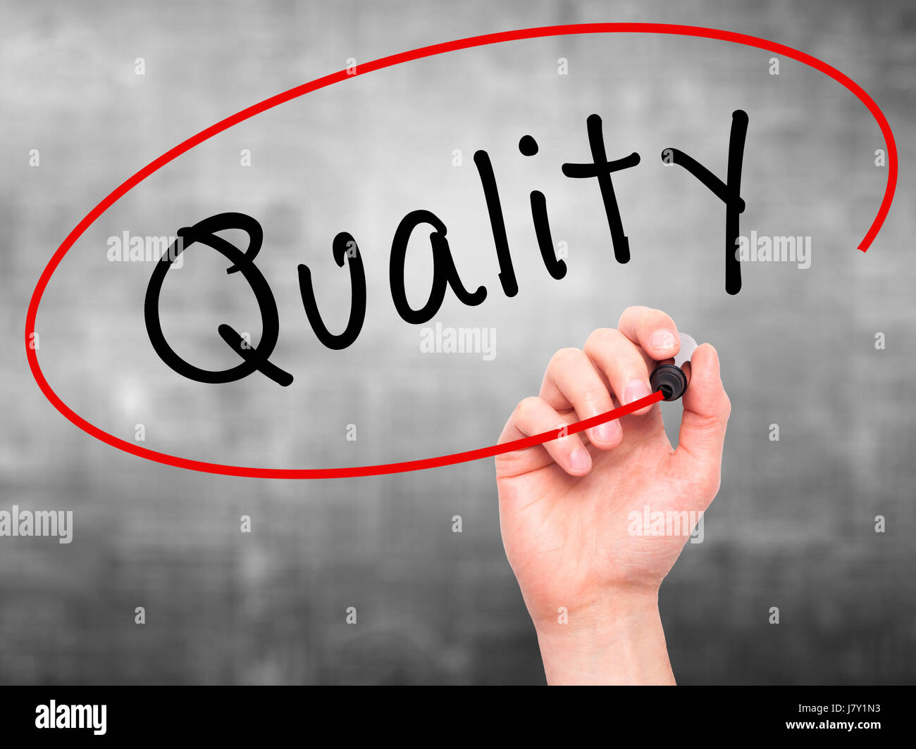 Man Hand writing Quality with marker on transparent wipe board ...