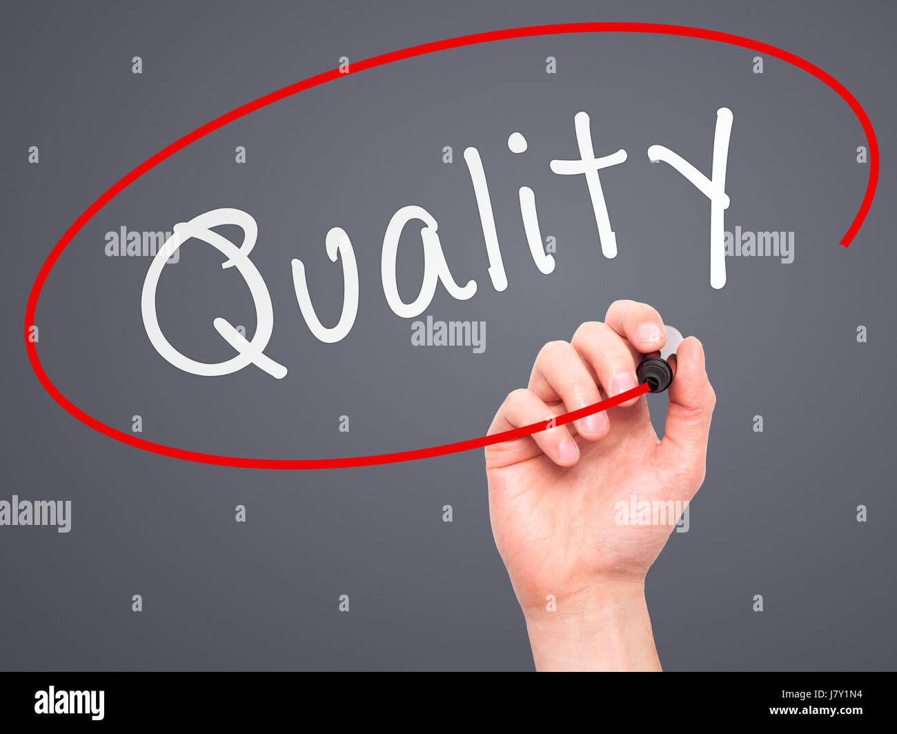 Man Hand writing Quality with marker on transparent wipe board ...