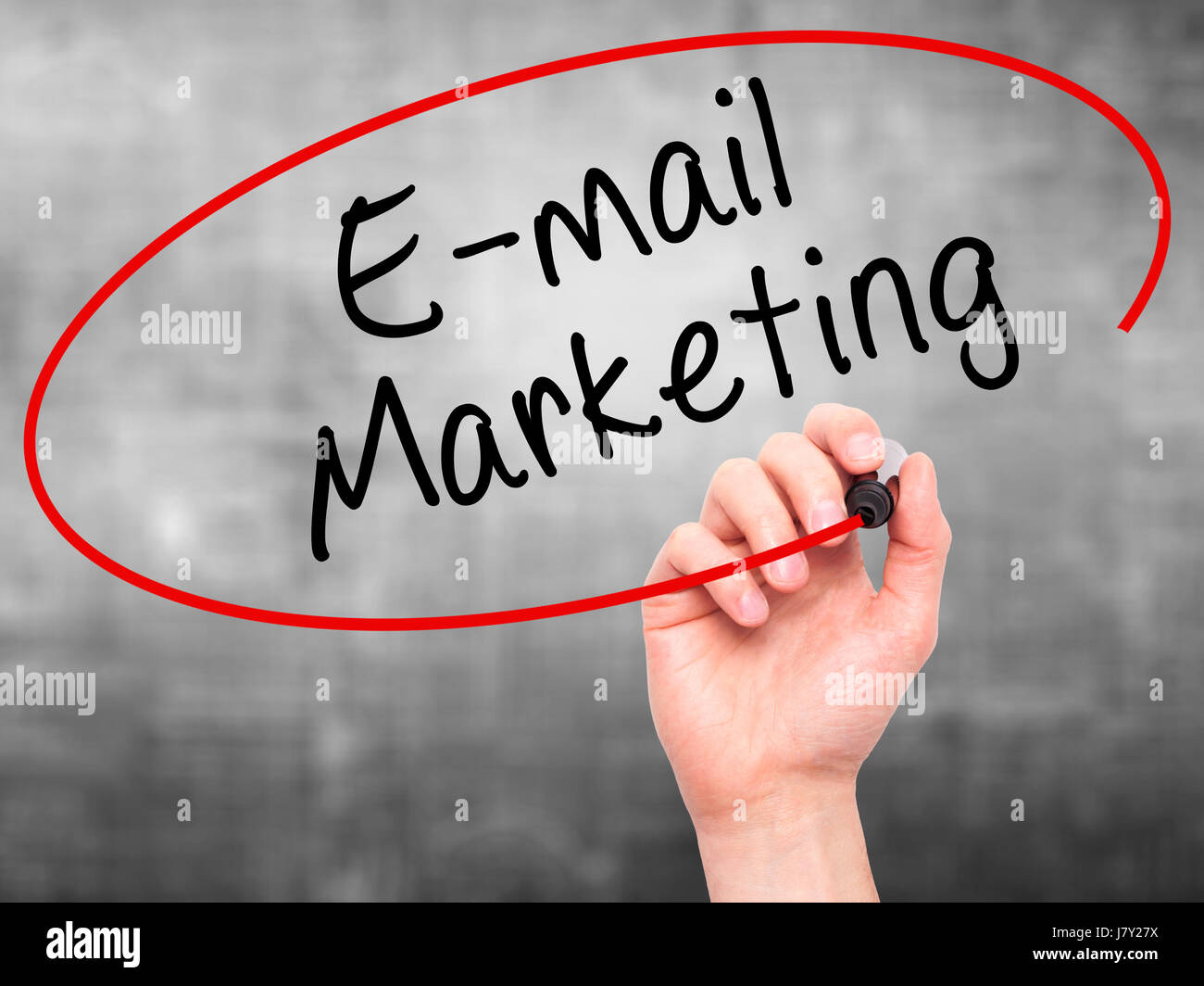 Man Hand writing E-mail Marketing with marker on transparent wipe board ...