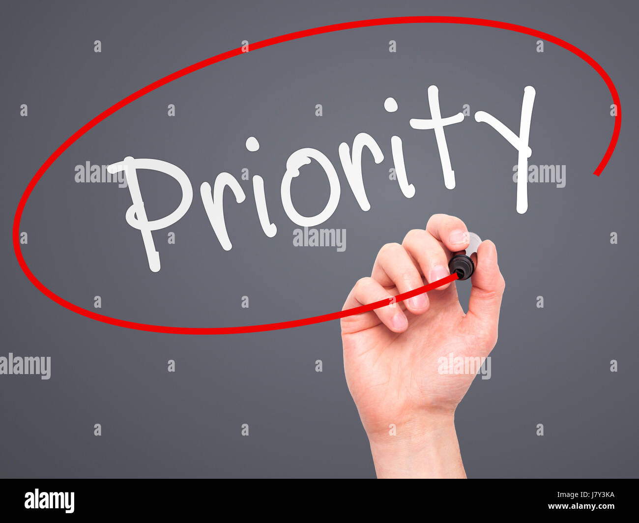 Man Hand writing Priority with marker on transparent wipe board ...