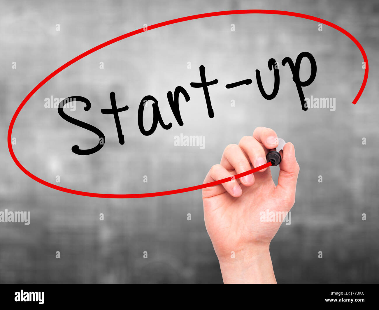 Man Hand writing Start-up with marker on transparent wipe board ...