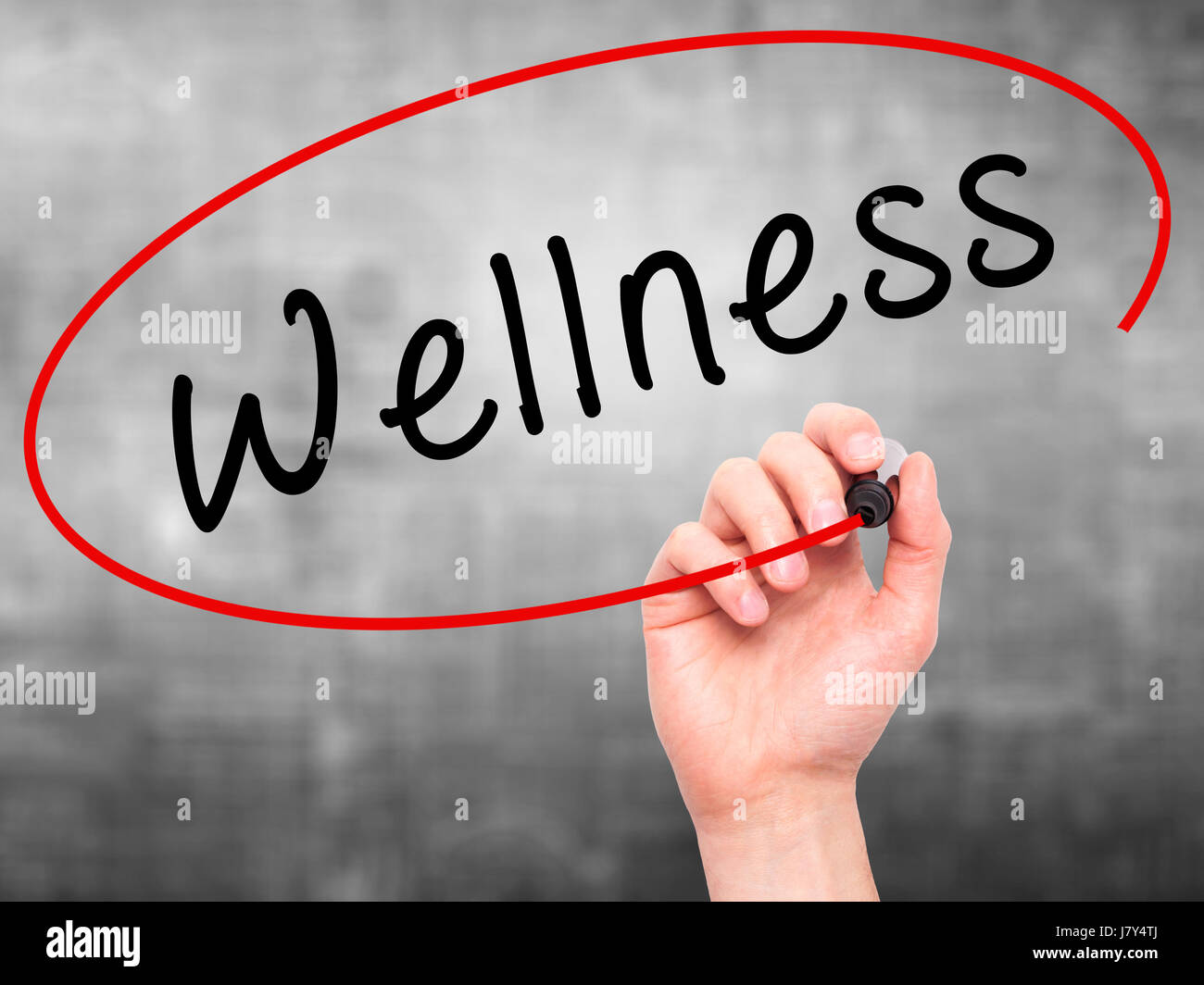 Man Hand writing Wellness with marker on transparent wipe board ...