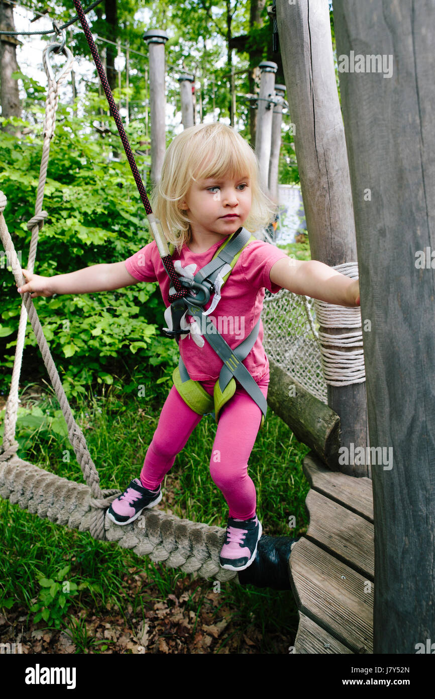 Young blond girl doing a ropes course in an adventure park Stock Photo ...