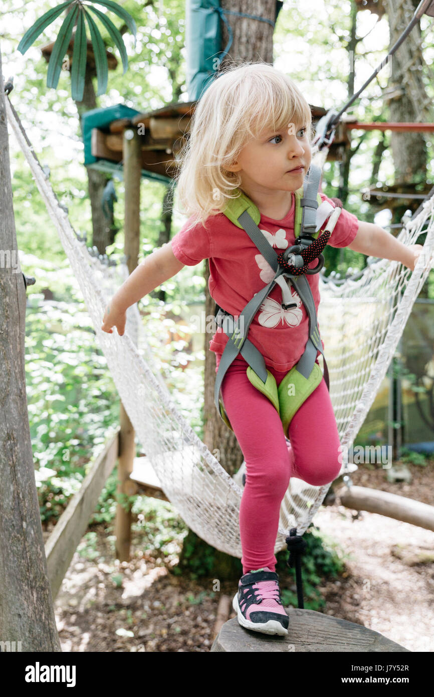 Young blond girl doing a ropes course in an adventure park Stock Photo ...