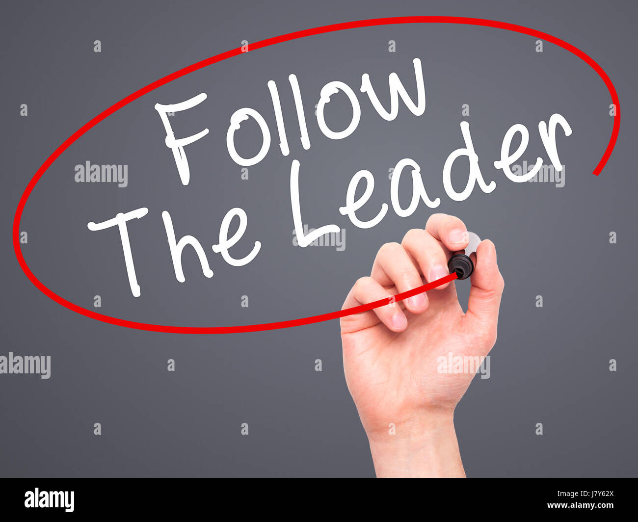 Man Hand writing Follow The Leader with black marker on visual screen ...