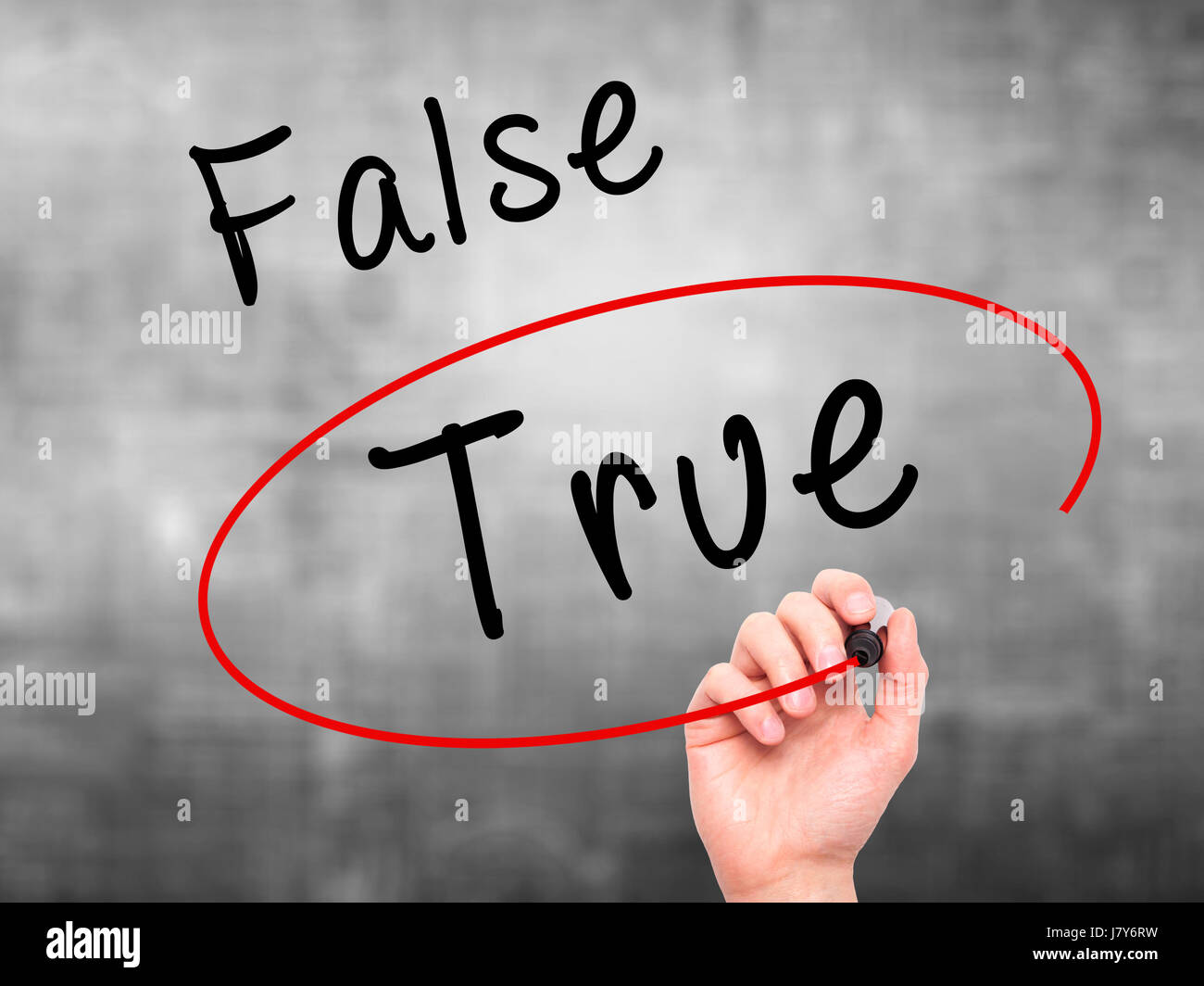 Man Hand writing an choosing True instead of False with black marker on ...