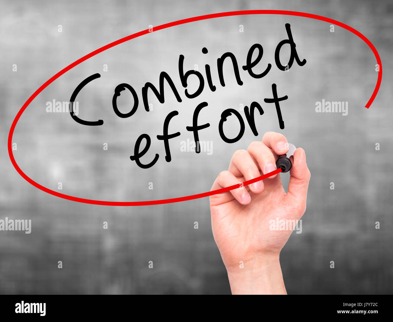 Man Hand writing Combined effort with black marker on visual screen ...