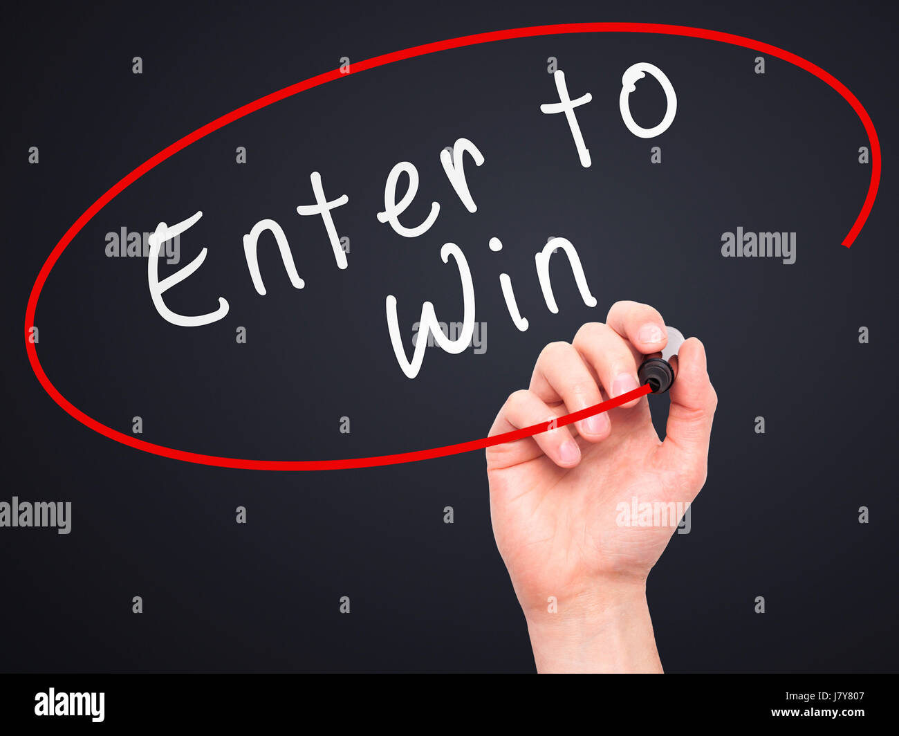 Man Hand writing Enter to Win with marker on transparent wipe board ...