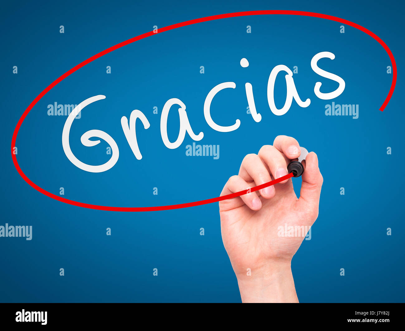 Man Hand writing Gracias with marker on transparent wipe board ...