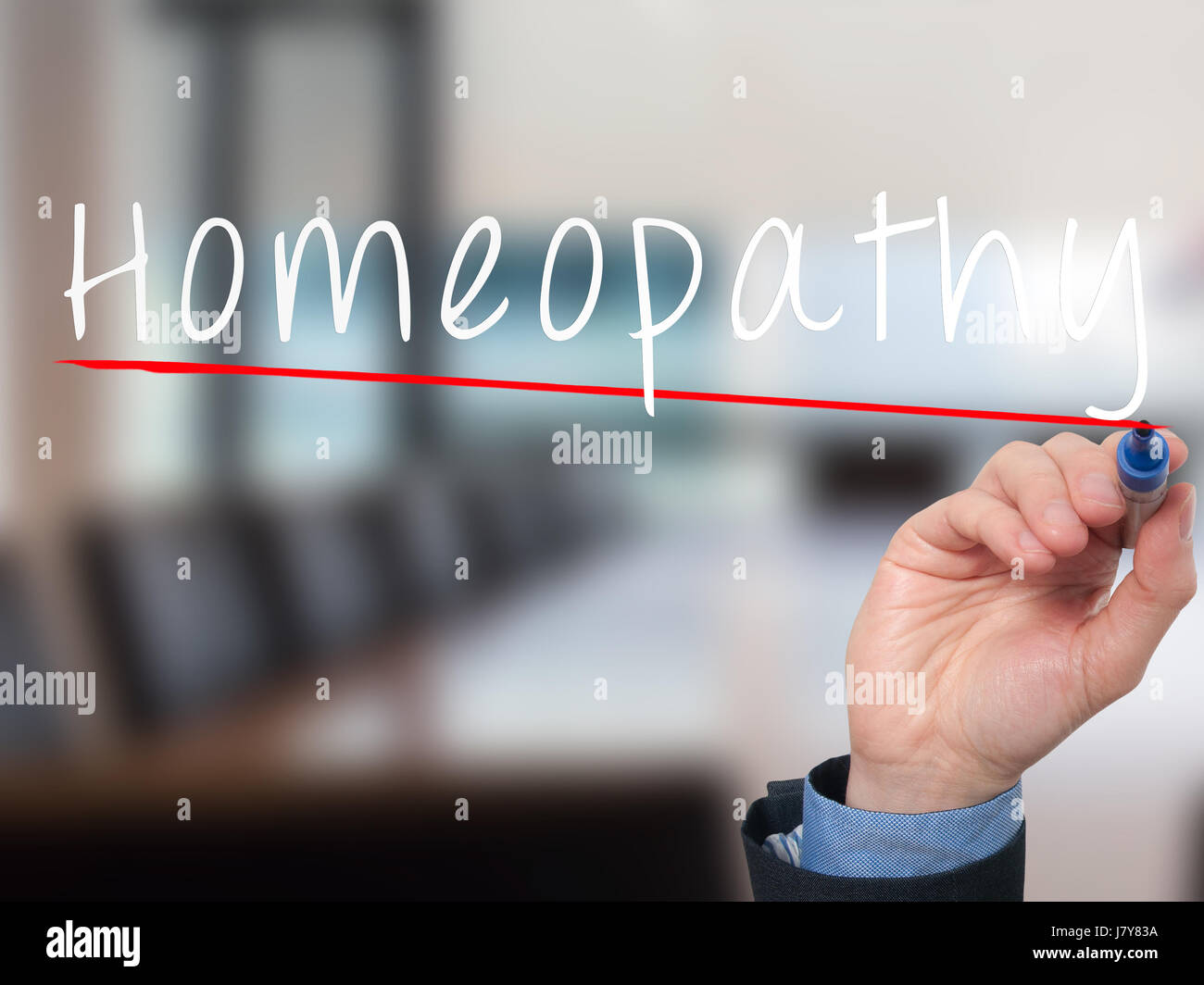 Man Hand writing Homeopathy with marker on transparent wipe board ...