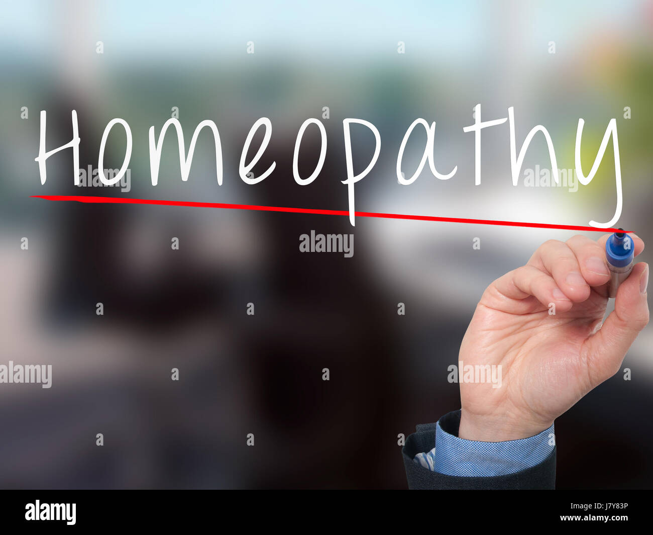 Man Hand writing Homeopathy with marker on transparent wipe board ...