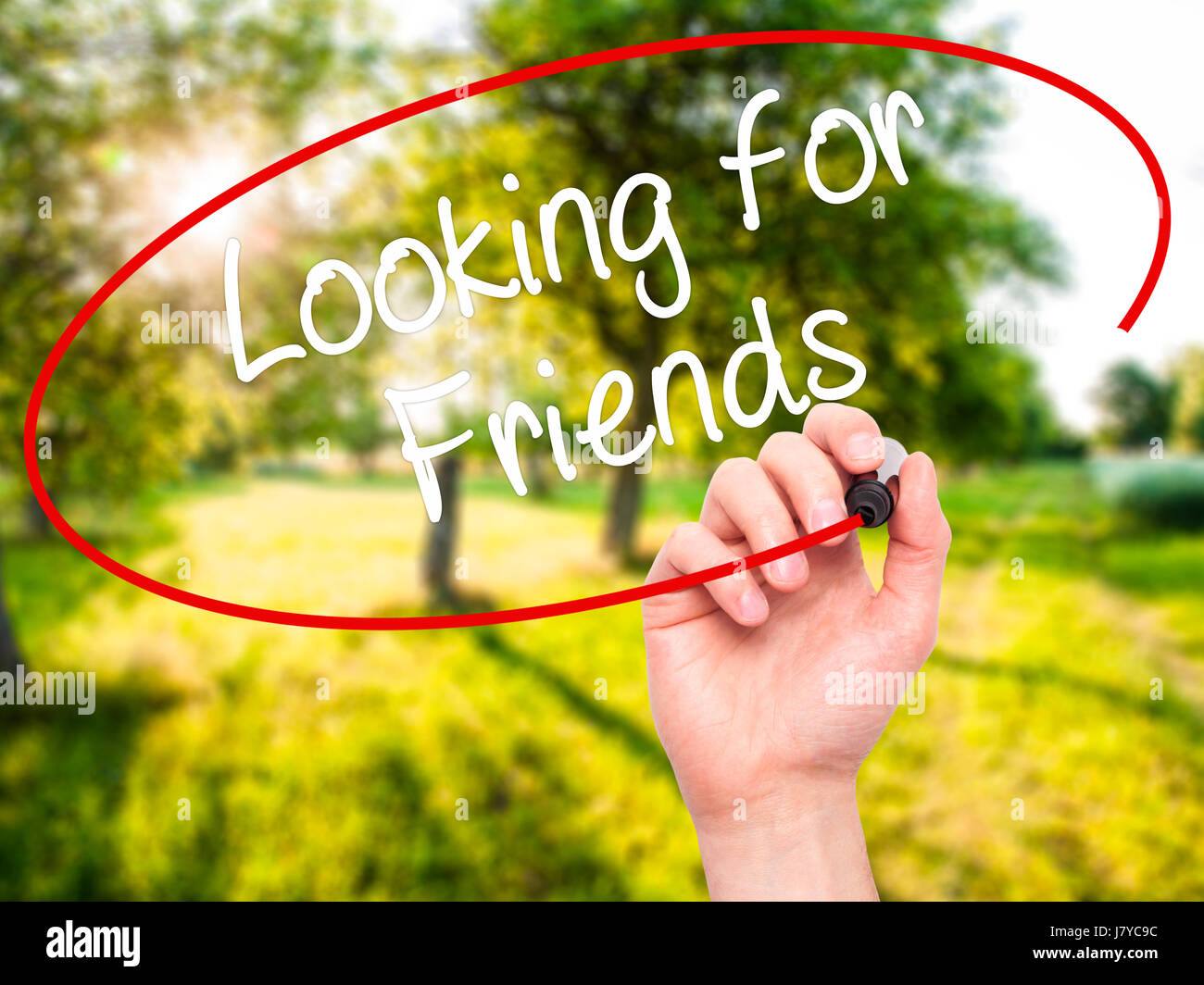 Man Hand writing Looking for Friends with black marker on visual screen ...