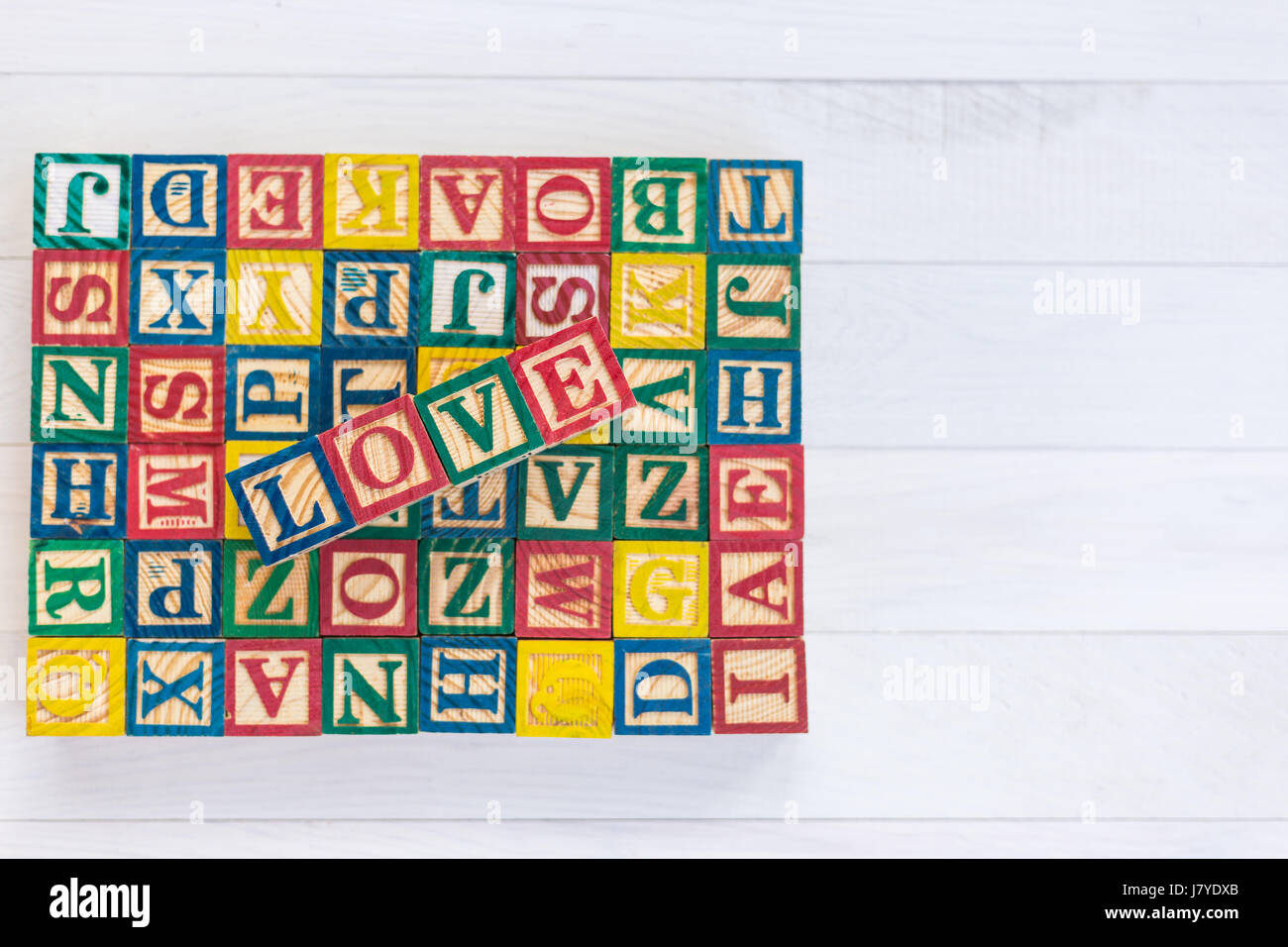 LOVE write in wooden alphabet block on white wooden board background ...