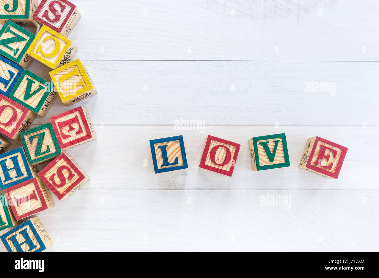 LOVE write in wooden alphabet block on white wooden board background ...