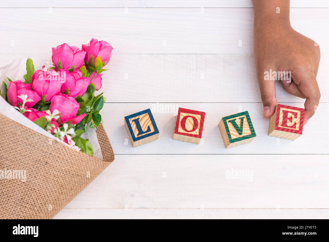 LOVE write in wooden alphabet block on white wooden board background ...