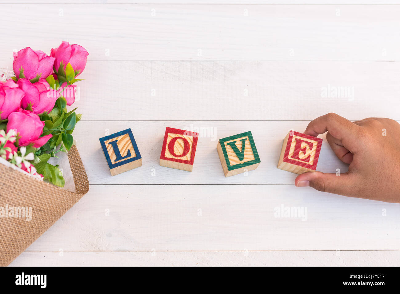 LOVE write in wooden alphabet block on white wooden board background ...