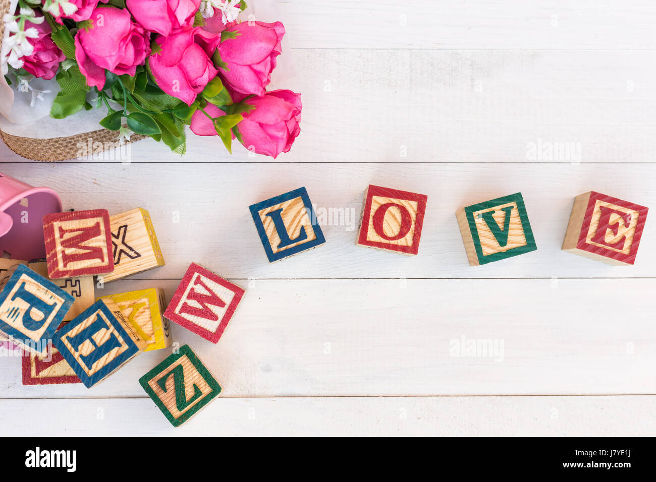LOVE write in wooden alphabet block on white wooden board background ...