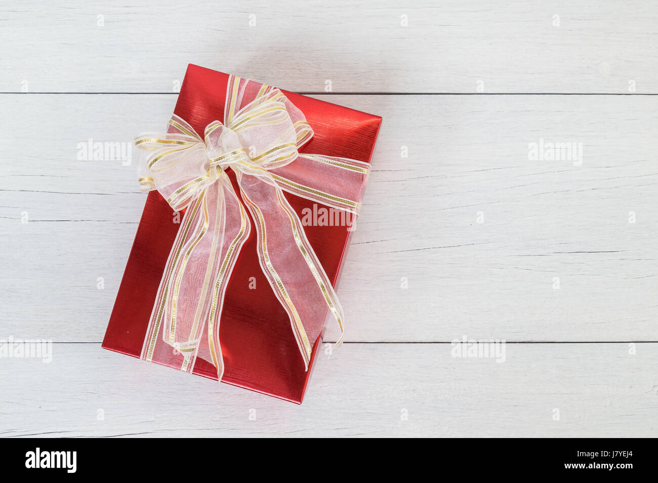 Top view color gift box with ribbon on white wooden plank background ...