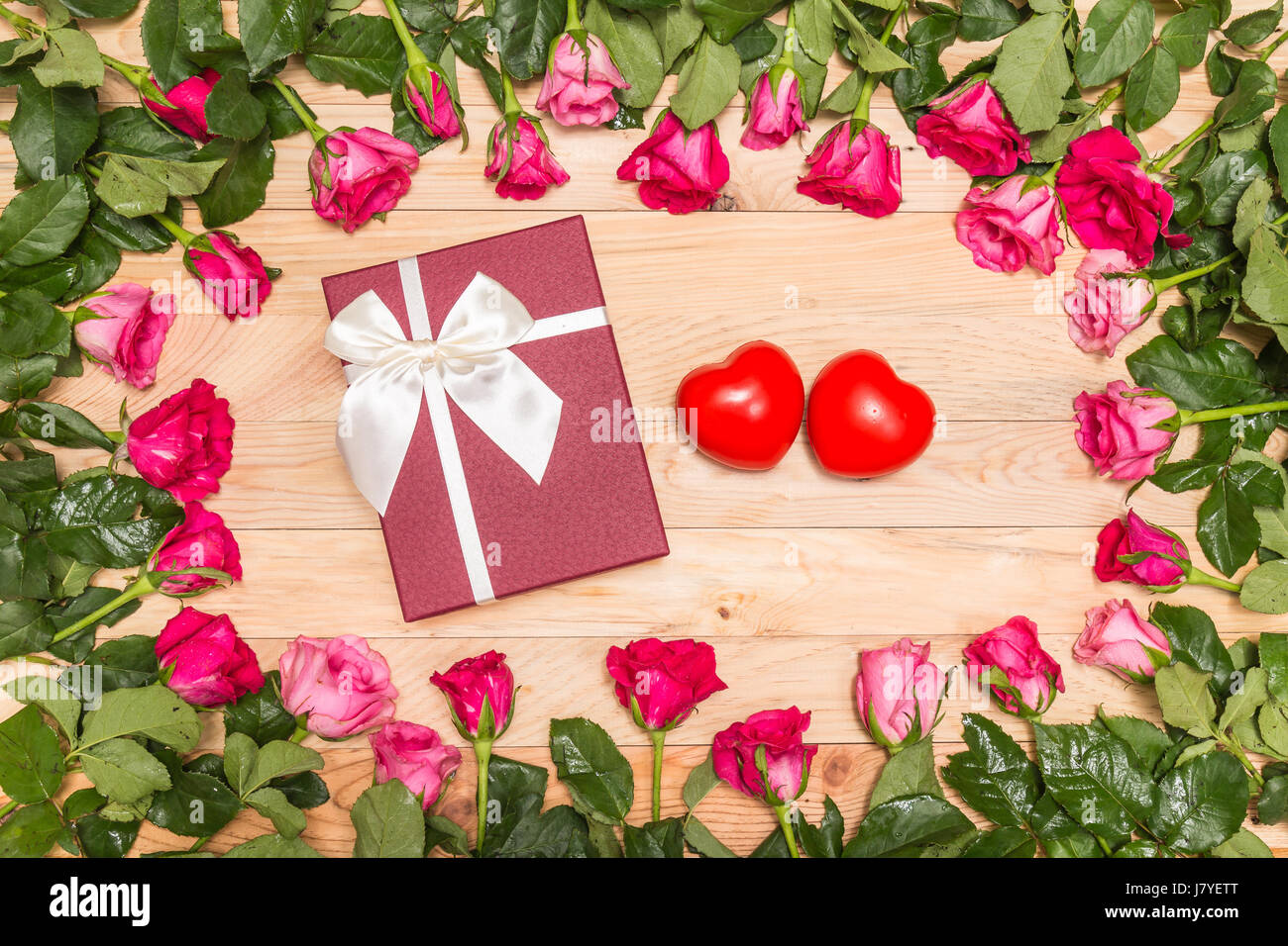 Top view fresh pink rose flower and gift box on wooden deck. For love ...