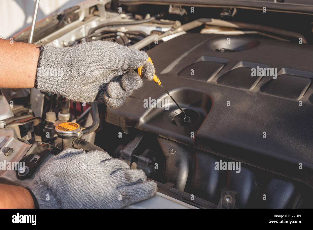 Hand of technician checking or fixing engine of modern car Stock Photo ...