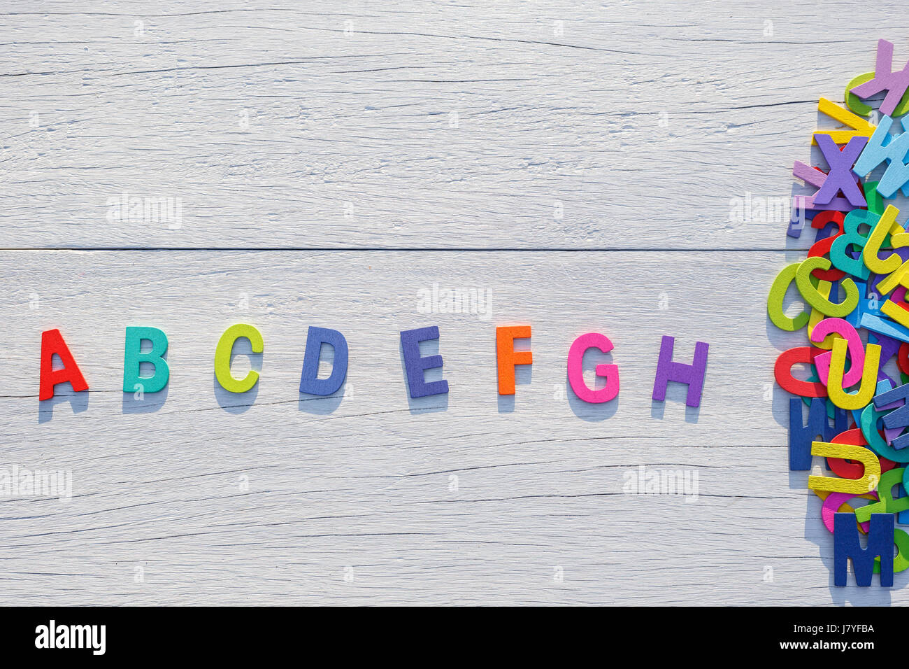 Colorful wooden alphabet. Top view on white wooden background Stock ...