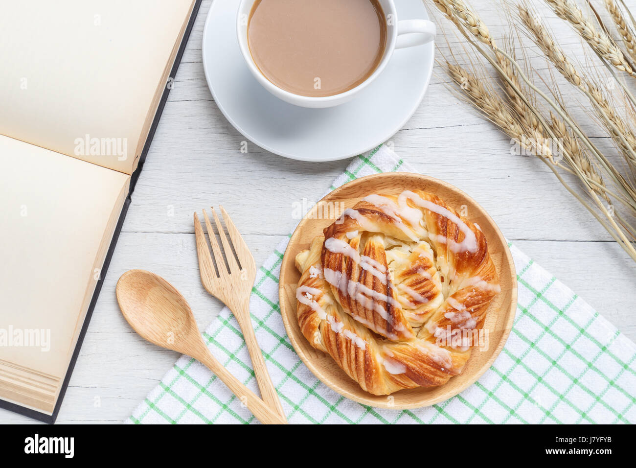 Top view danish pastries, coffee and note book on white wooden table ...