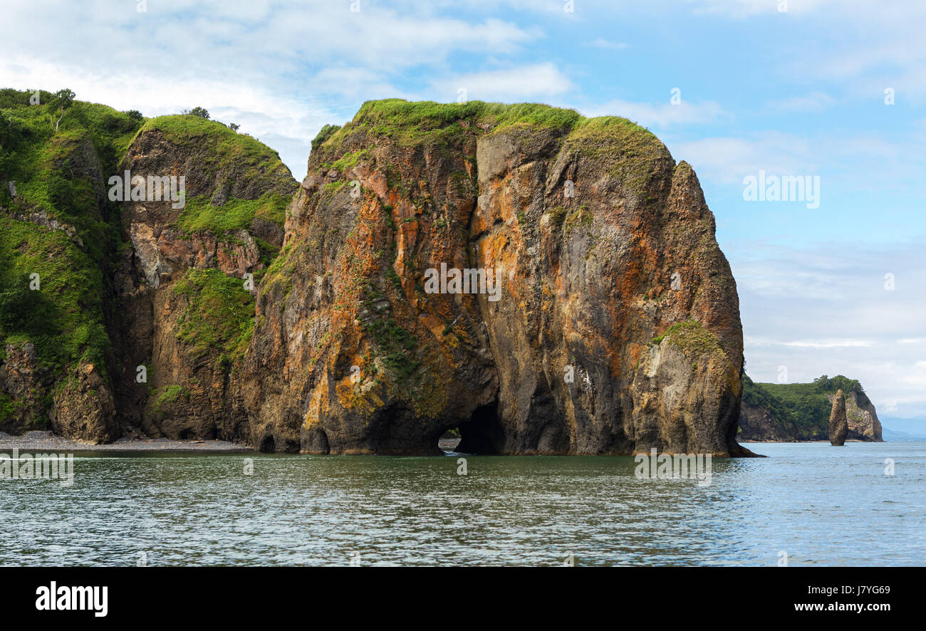 Rocks with caves and grottoes in Avacha Bay of Pacific Ocean. The coast ...