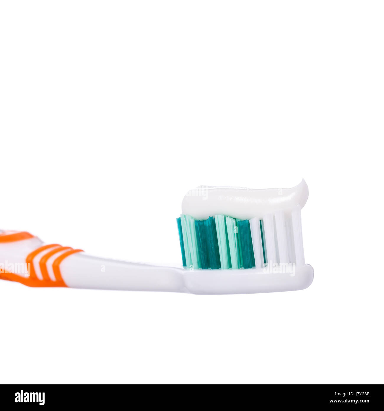 New orange toothbrush with toothpaste. Studio shot isolated on white ...