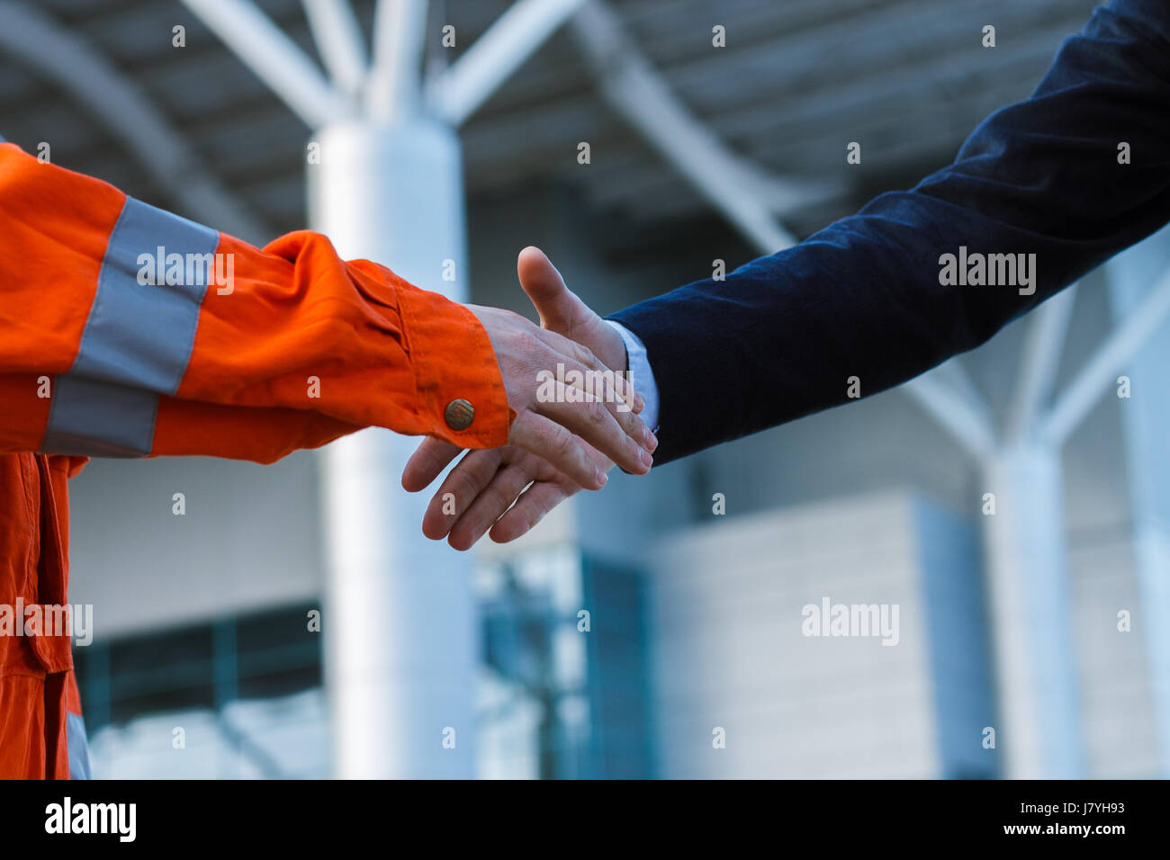 businessman handshaking with worker. Handshake of suit and boilersuit ...