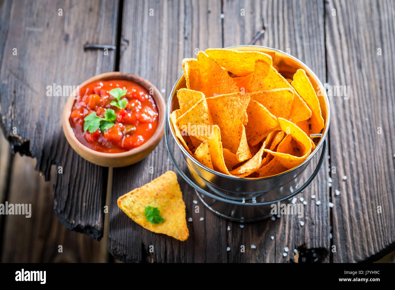 Golden nachos with salt and spicy red sauce Stock Photo - Alamy
