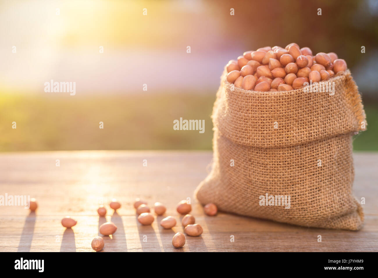 Close up peanut in small sack on wooden table. Outdoor shooting with ...