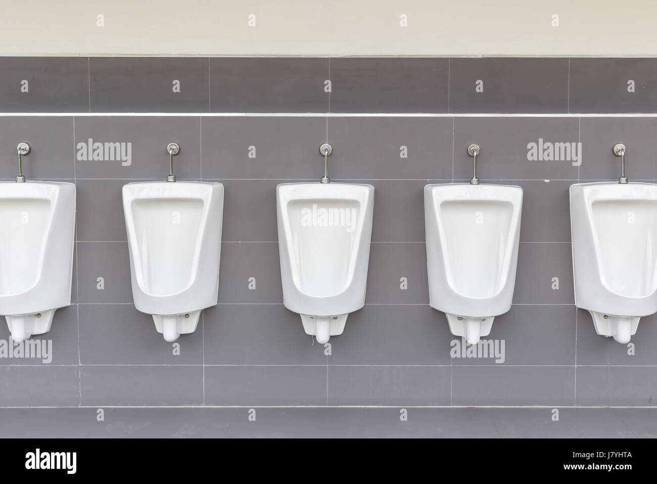 New row of outdoor urinals on grey wall in men public toilet Stock ...