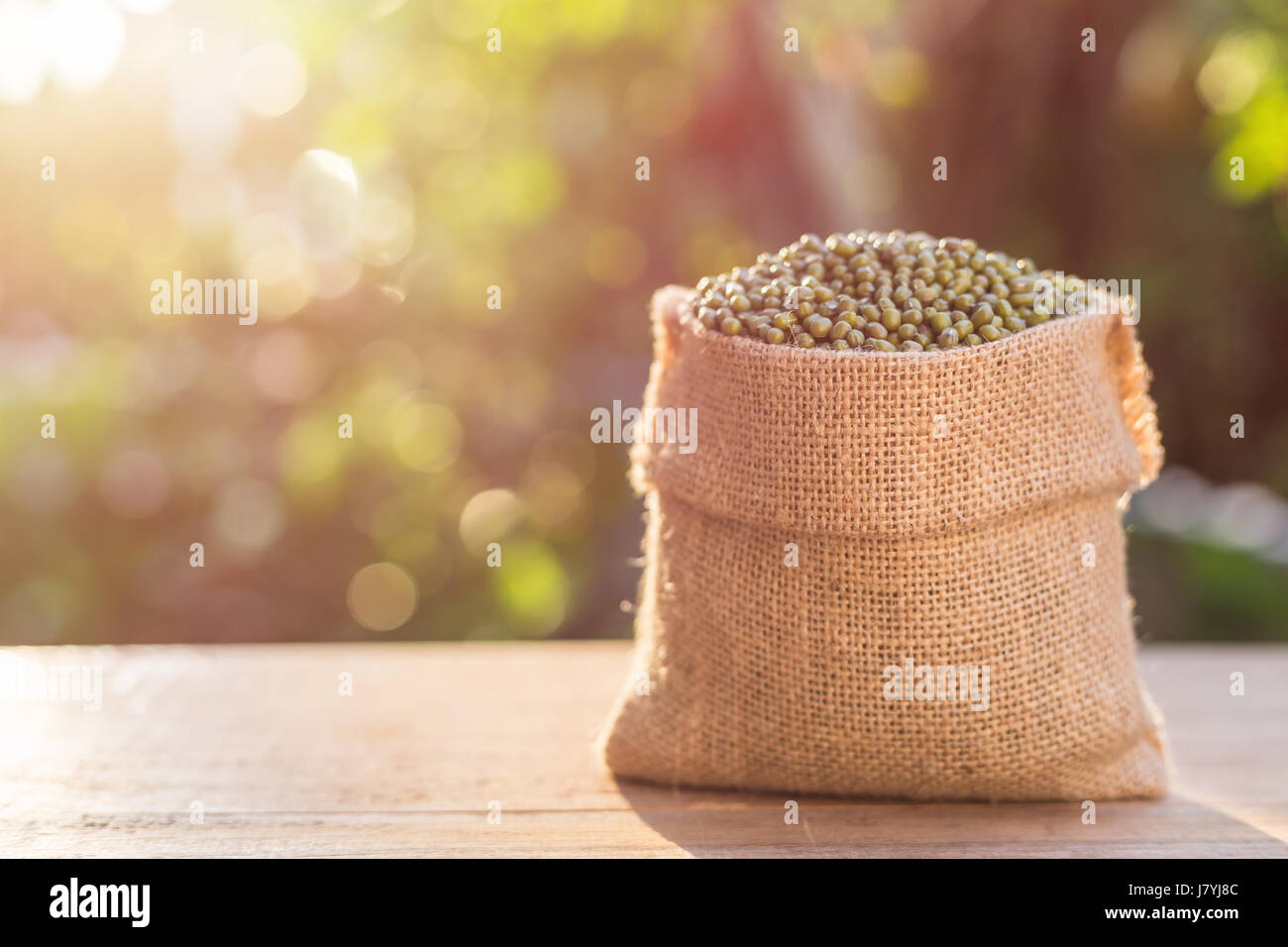 Close up of mung beans in small wooden sack on wooden table. Outdoor ...