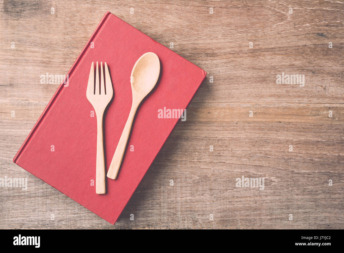 Top view spoon, fork and book on wooden plank background. Eating ...