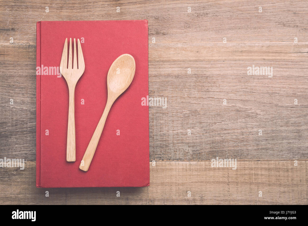 Top view spoon, fork and book on wooden plank background. Eating ...