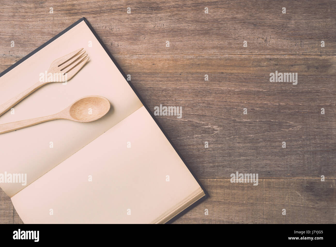 Top view spoon, fork and book on wooden plank background. Eating ...