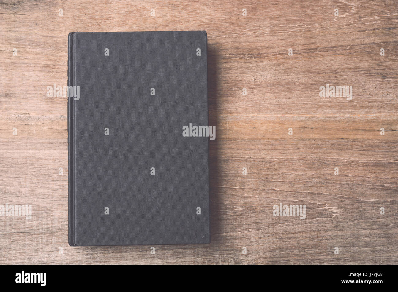 Top view old book on wooden plank background Stock Photo - Alamy