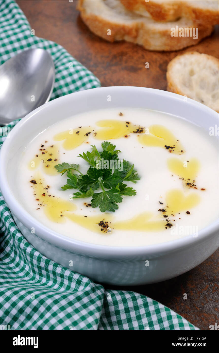 A bowl of white bean puree soup with spicy butter and spices, herb ...