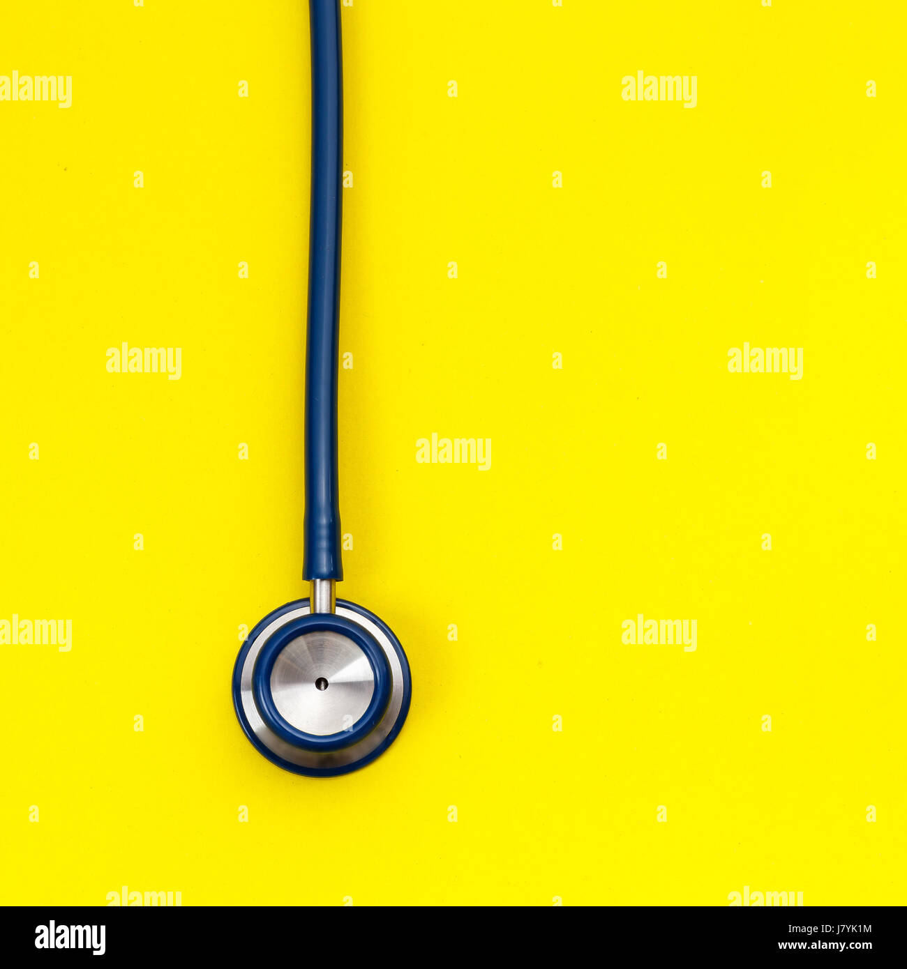 Top view blue stethoscope on yellow background. For check heart or ...