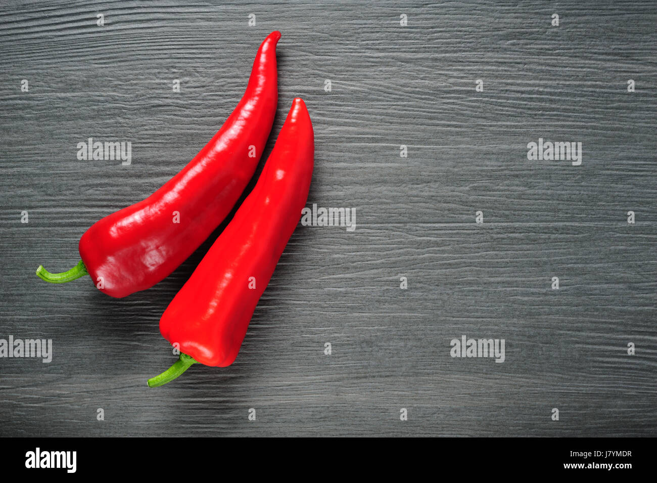 Two red Kapia peppers on a dark shale stone background Stock Photo - Alamy