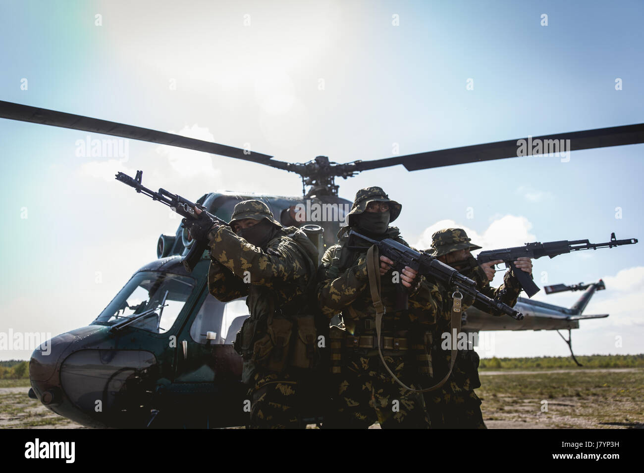 Photos of a group of military men with a gun in front of a helicopter ...