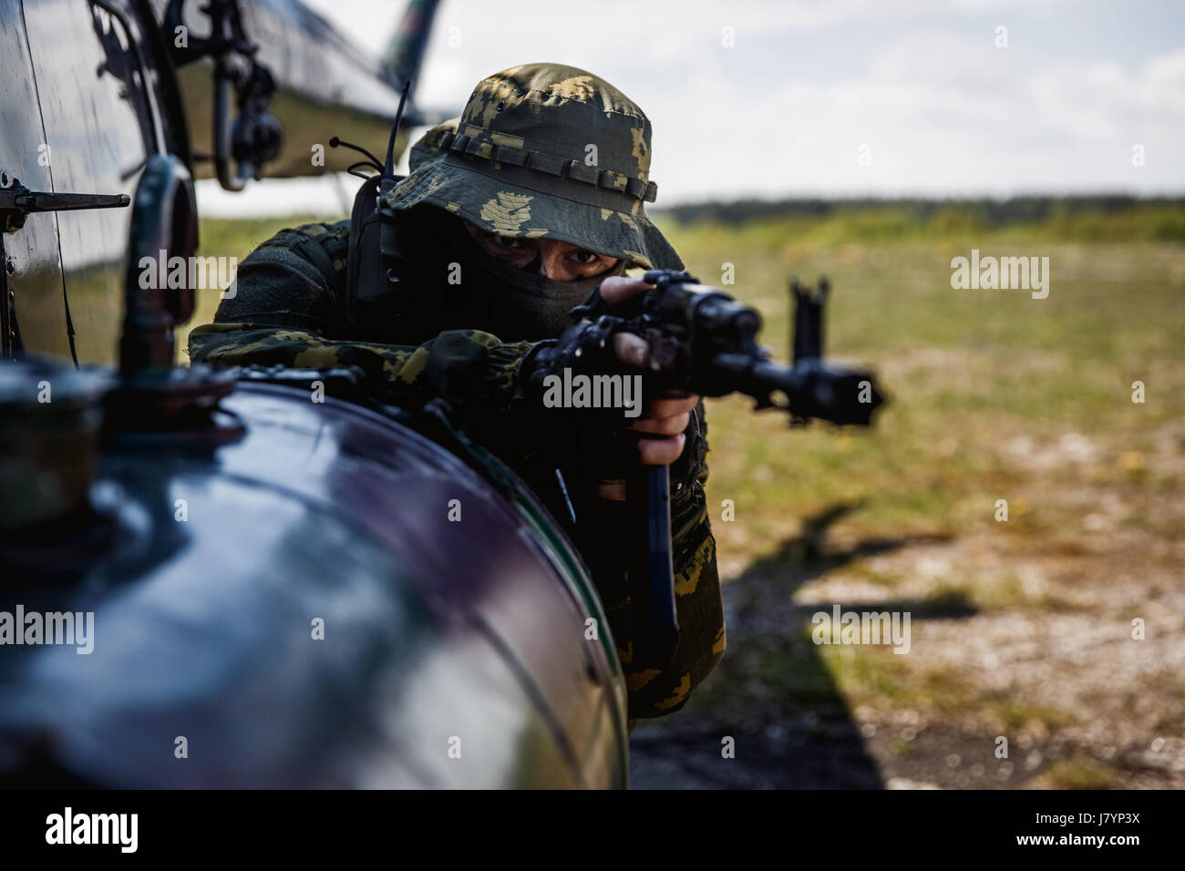 Photo of a soldier with an automatic rifle at a helicopter Stock Photo ...