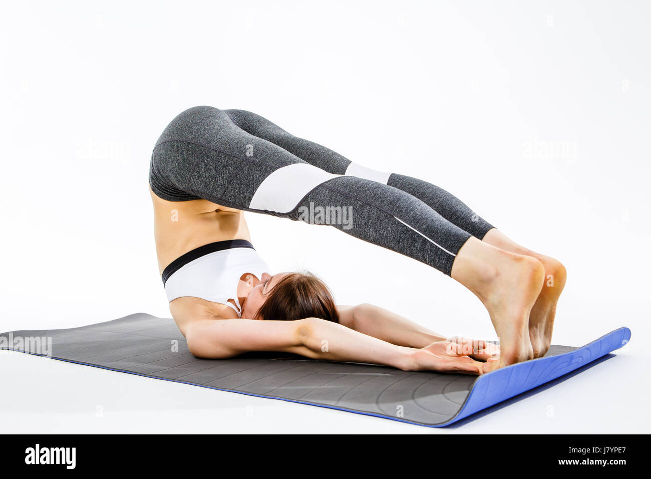 Woman doing stretching on rug at isolated background Stock Photo - Alamy