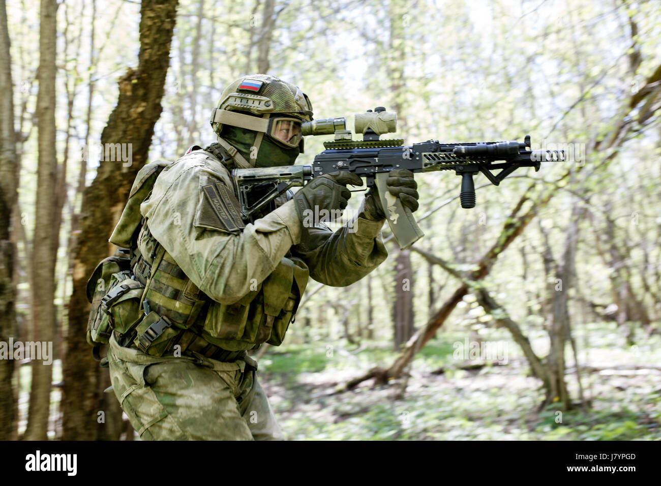 Soldier takes aim in forest with submachine gun Stock Photo - Alamy