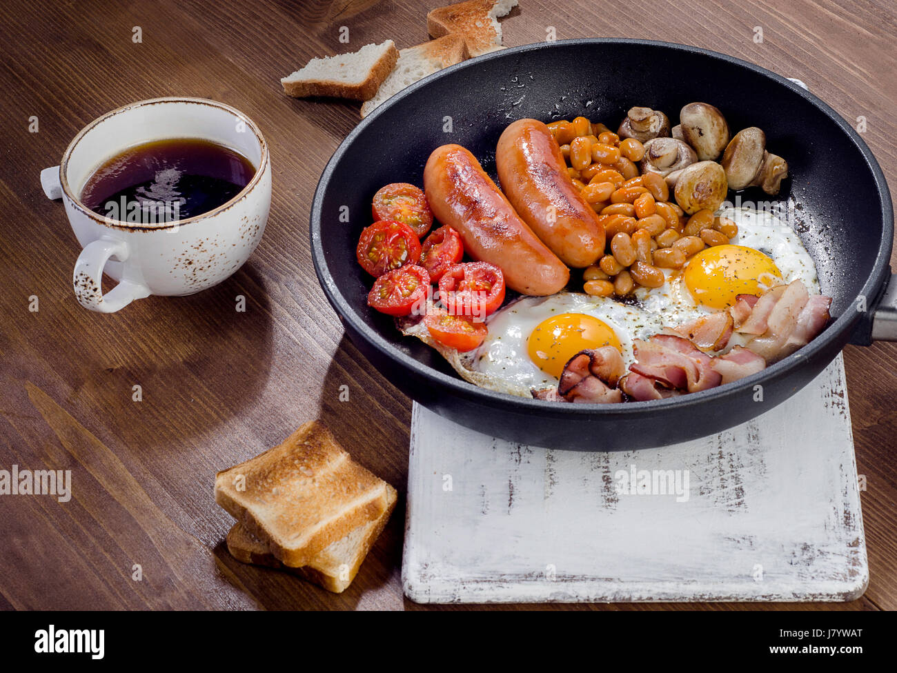 Full English breakfast with fried eggs, sausages, bacon, beans, toasts ...