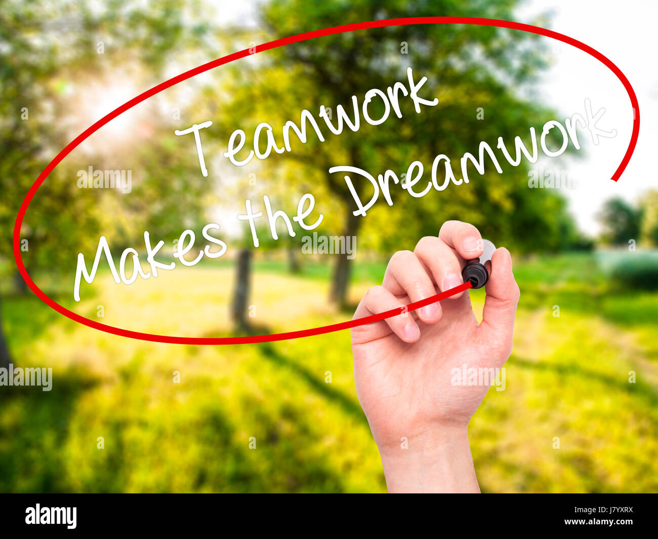 Man Hand writing Teamwork Makes the Dreamwork with black marker on ...