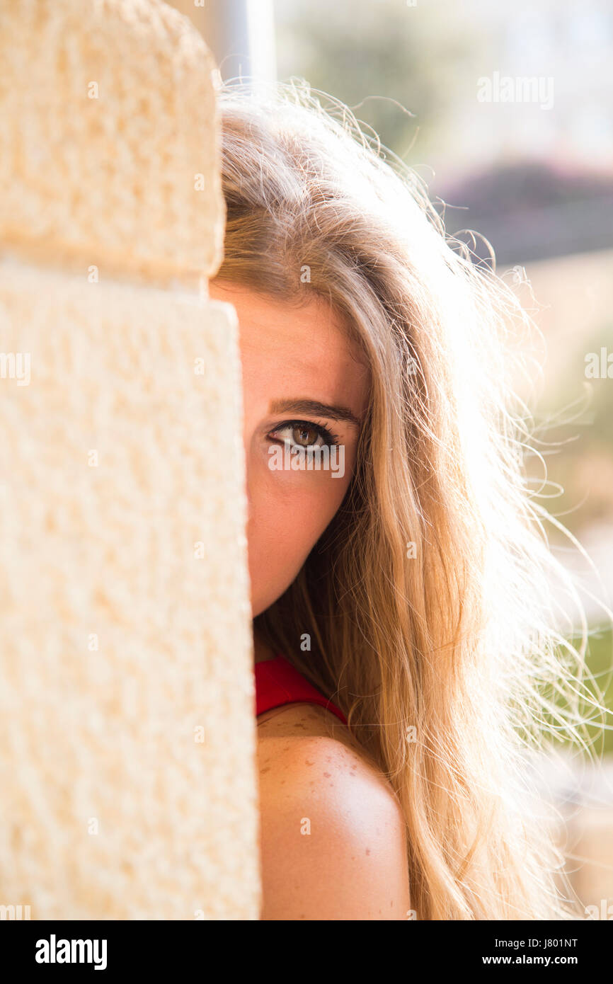 Woman hiding behind wall a watching hi-res stock photography and images ...