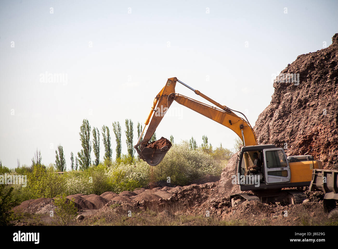 A large construction excavator of yellow color on the construction site ...